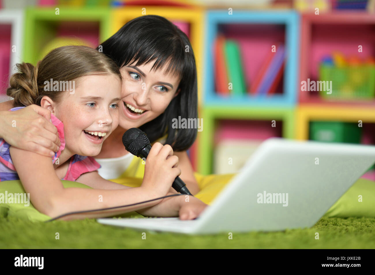 mother and daughter singing karaoke Stock Photo - Alamy