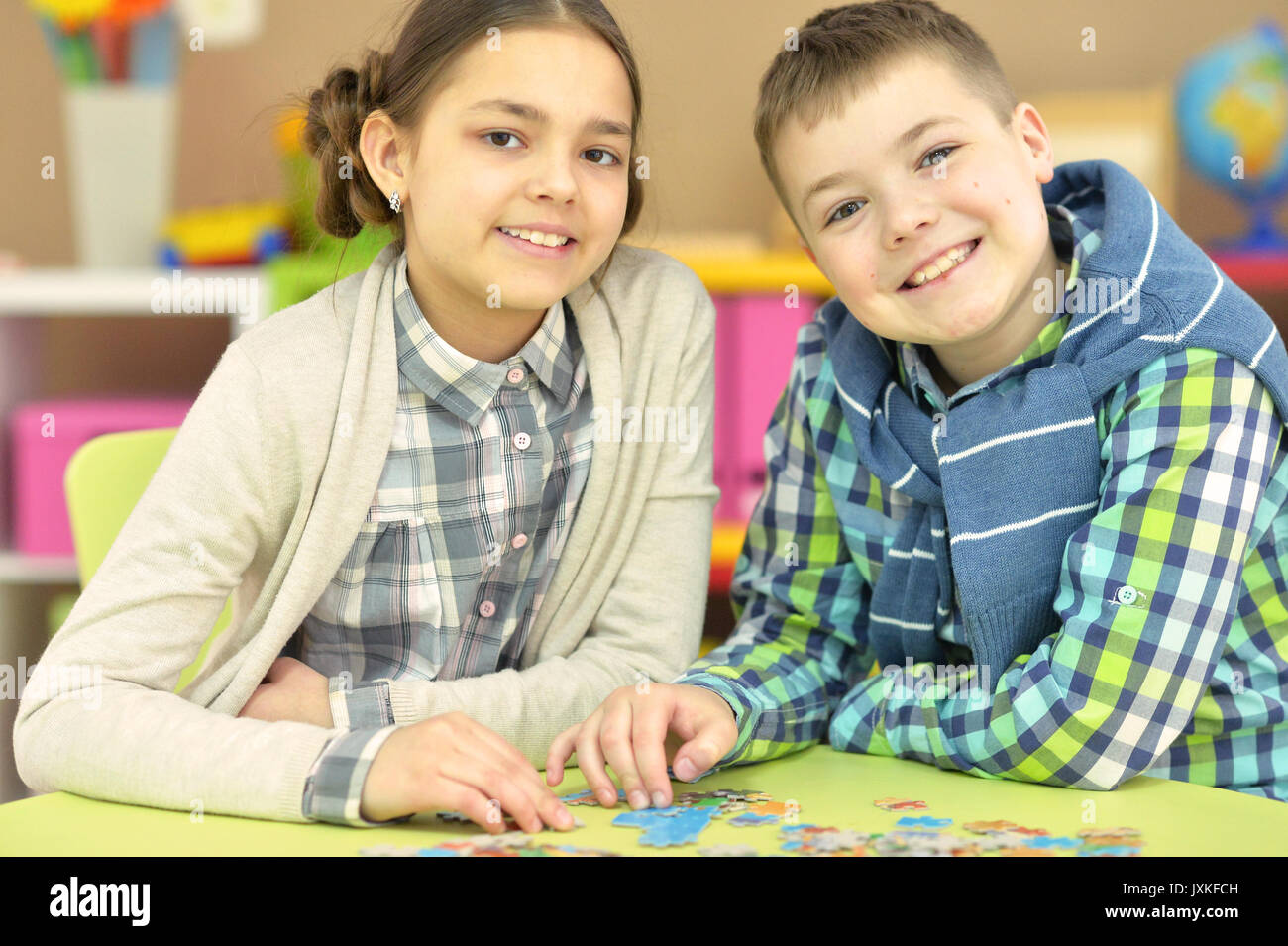 Brother and sister collecting puzzle Stock Photo - Alamy
