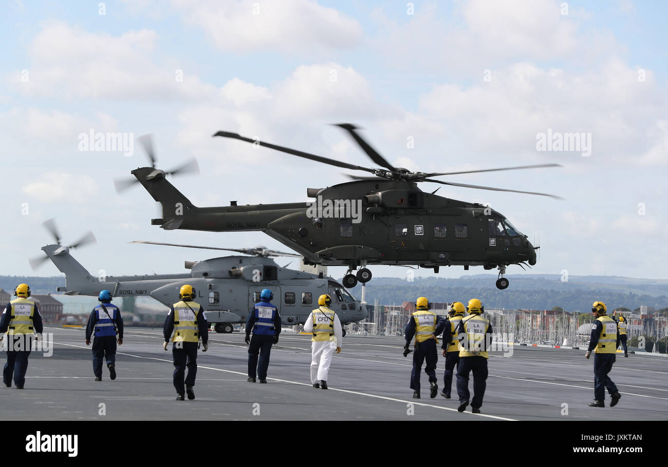 A Merlin helicopter takes off from the flight deck of HMS Queen ...