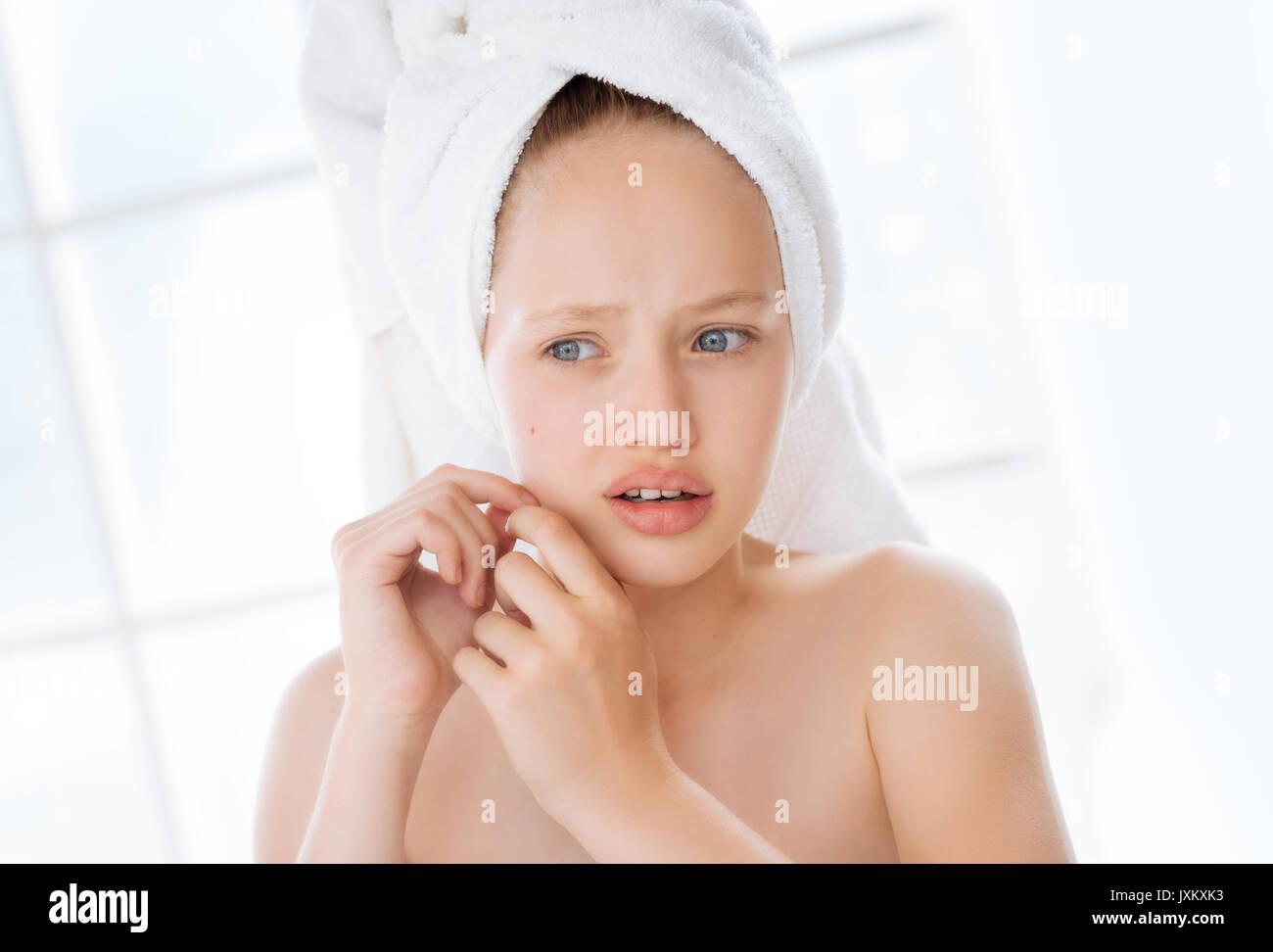 Scared girl looking at her pimple on cheek Stock Photo - Alamy