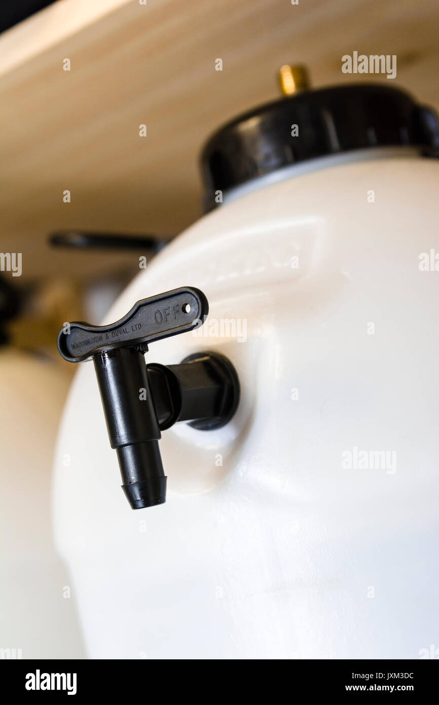Home brew white plastic pressure kegs with taps in a home-brew shed ...