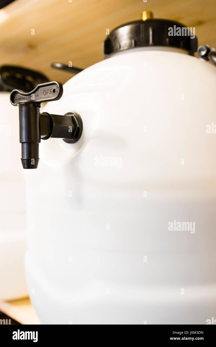 Home brew white plastic pressure kegs with taps in a home-brew shed ...