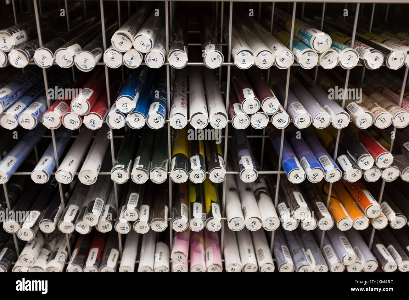 Posters in tubes on a rack, all numbered Stock Photo - Alamy