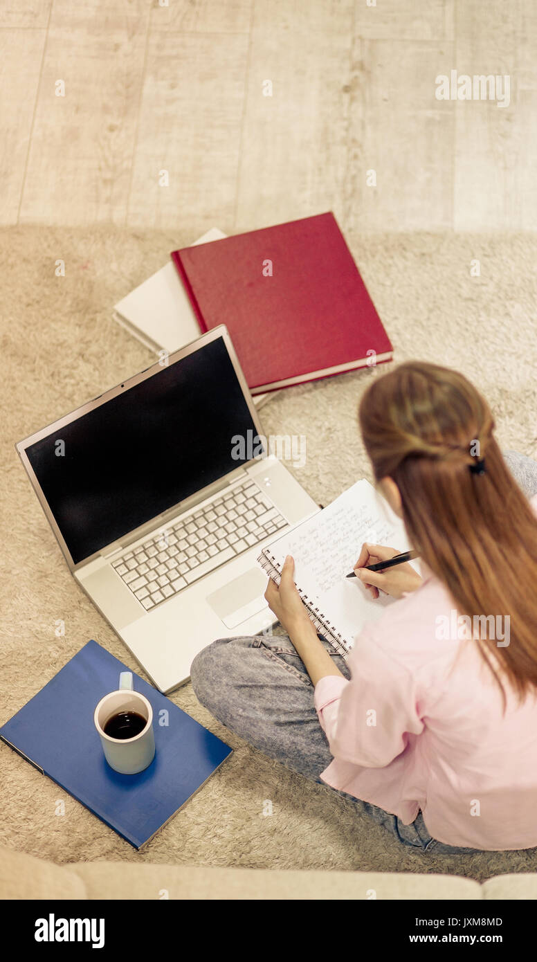 Young student learning at home, sitting on carpet in living room Stock ...