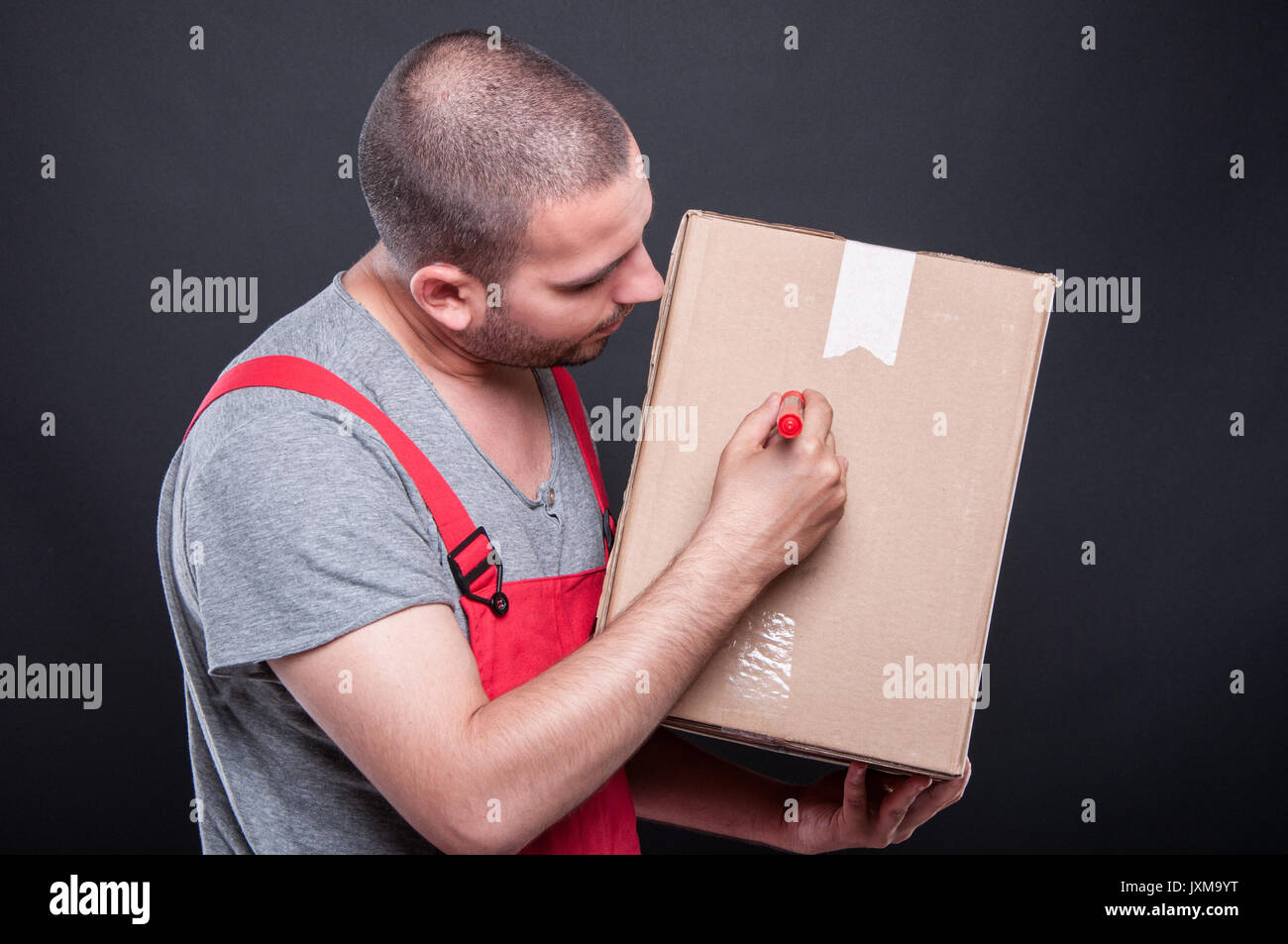Mover guy writing on box with red marker on black background Stock ...