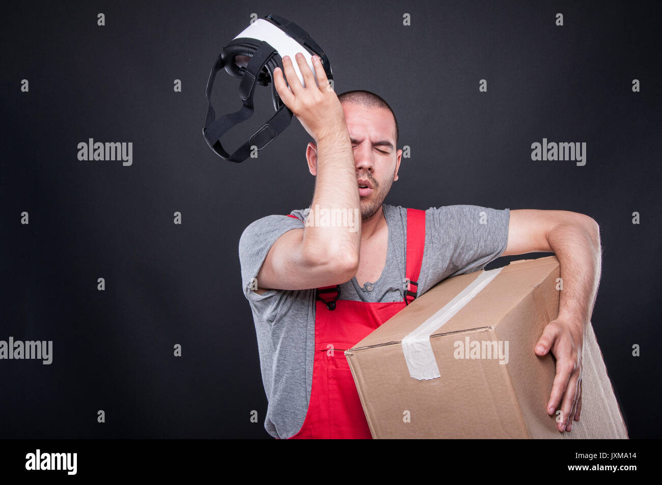 Mover guy holding box putting out vr glasses and rubbing his eyes on ...