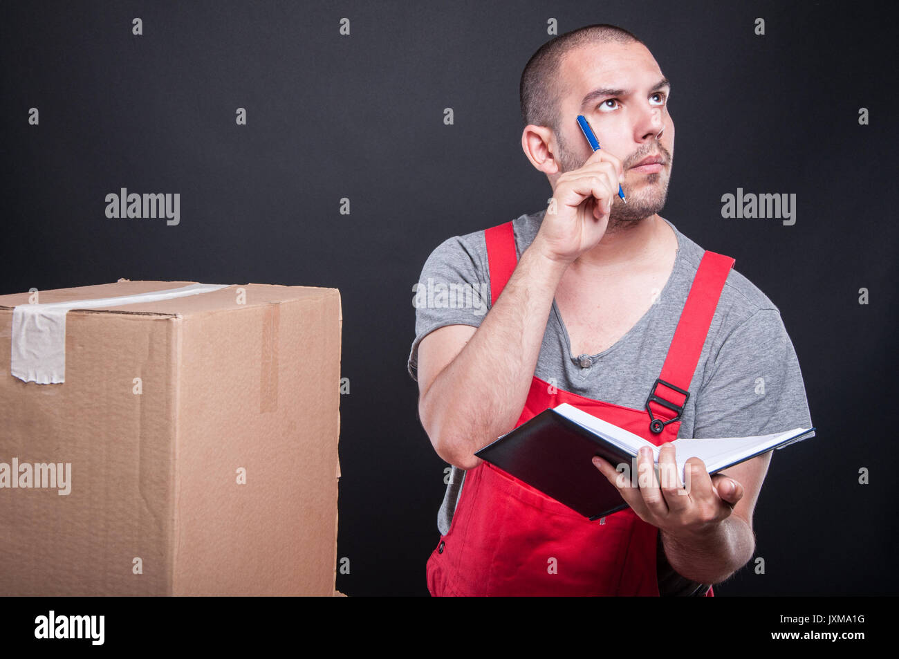 Mover guy holding agenda making thinking gesture with cardboard boxes ...