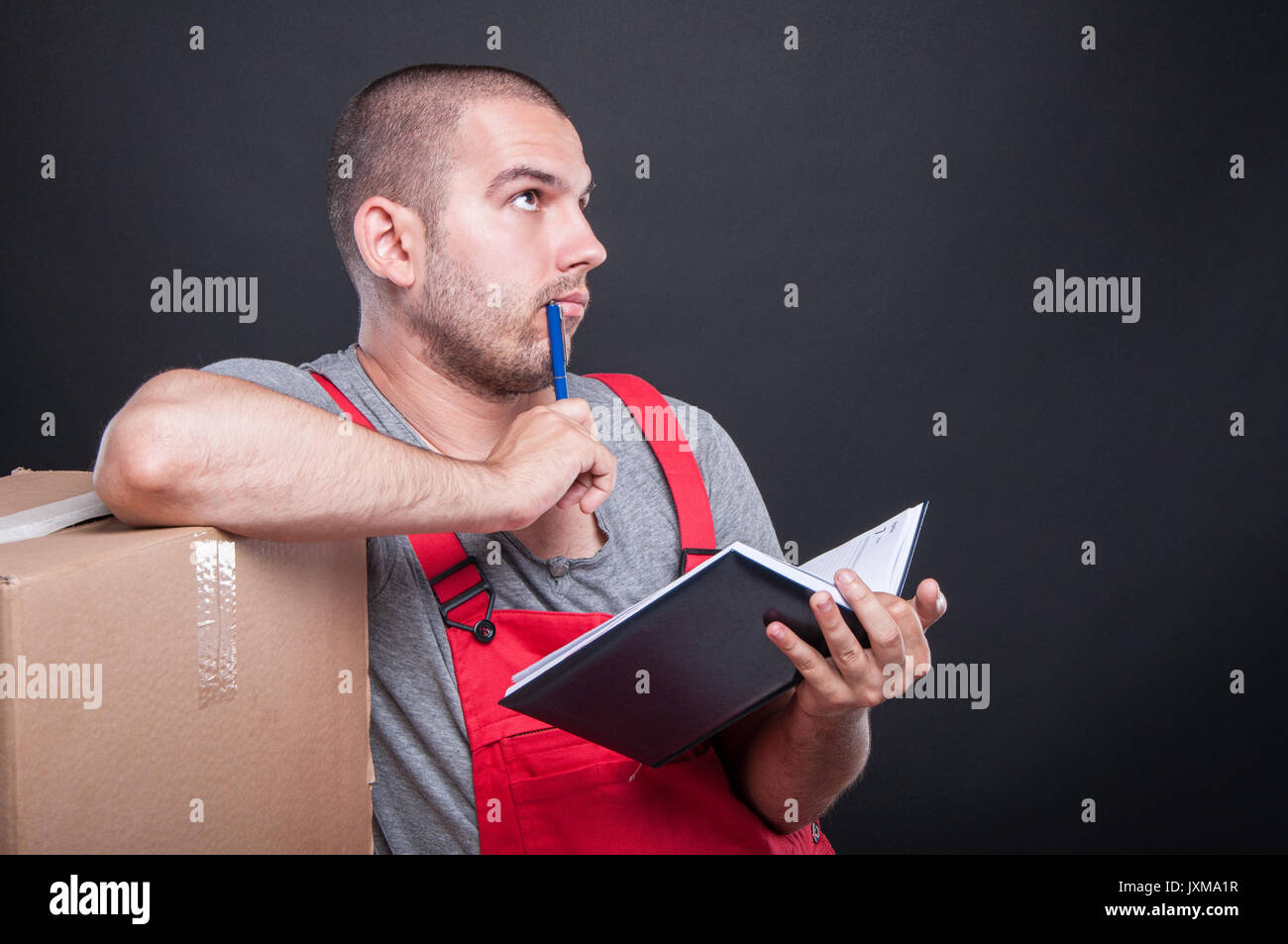 Mover guy holding agenda making thinking gesture on black background ...