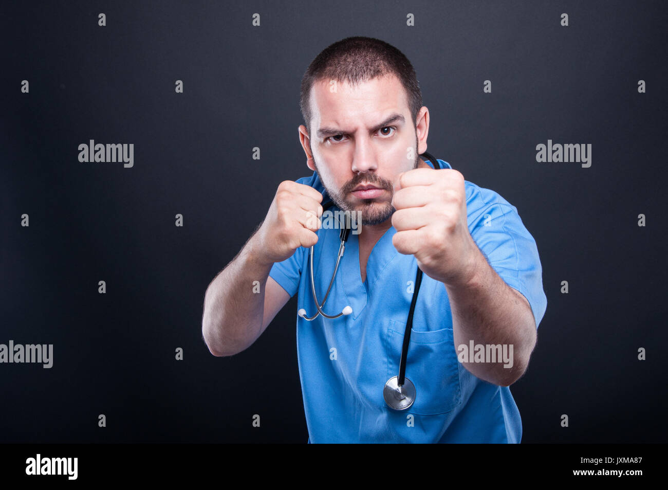 Mad doctor wearing scrubs with stethoscope fighting showing fist on ...