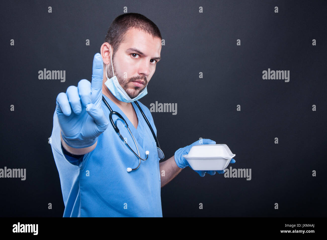Doctor with stethoscope making taking lunch break on black background ...