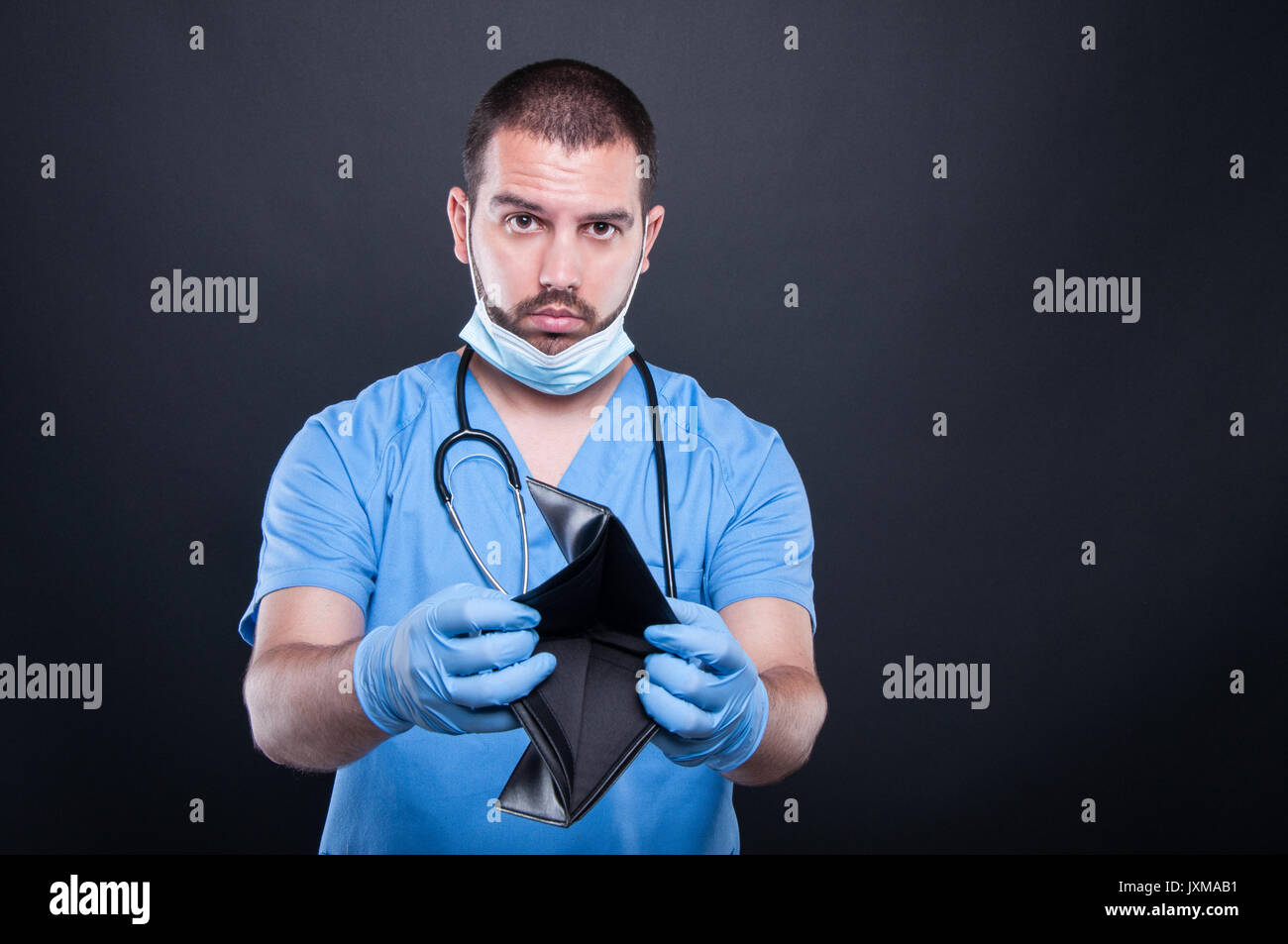 Doctor or medic showing empty wallet looking sad on black background ... Doctor or medic showing empty wallet looking sad on black background ...