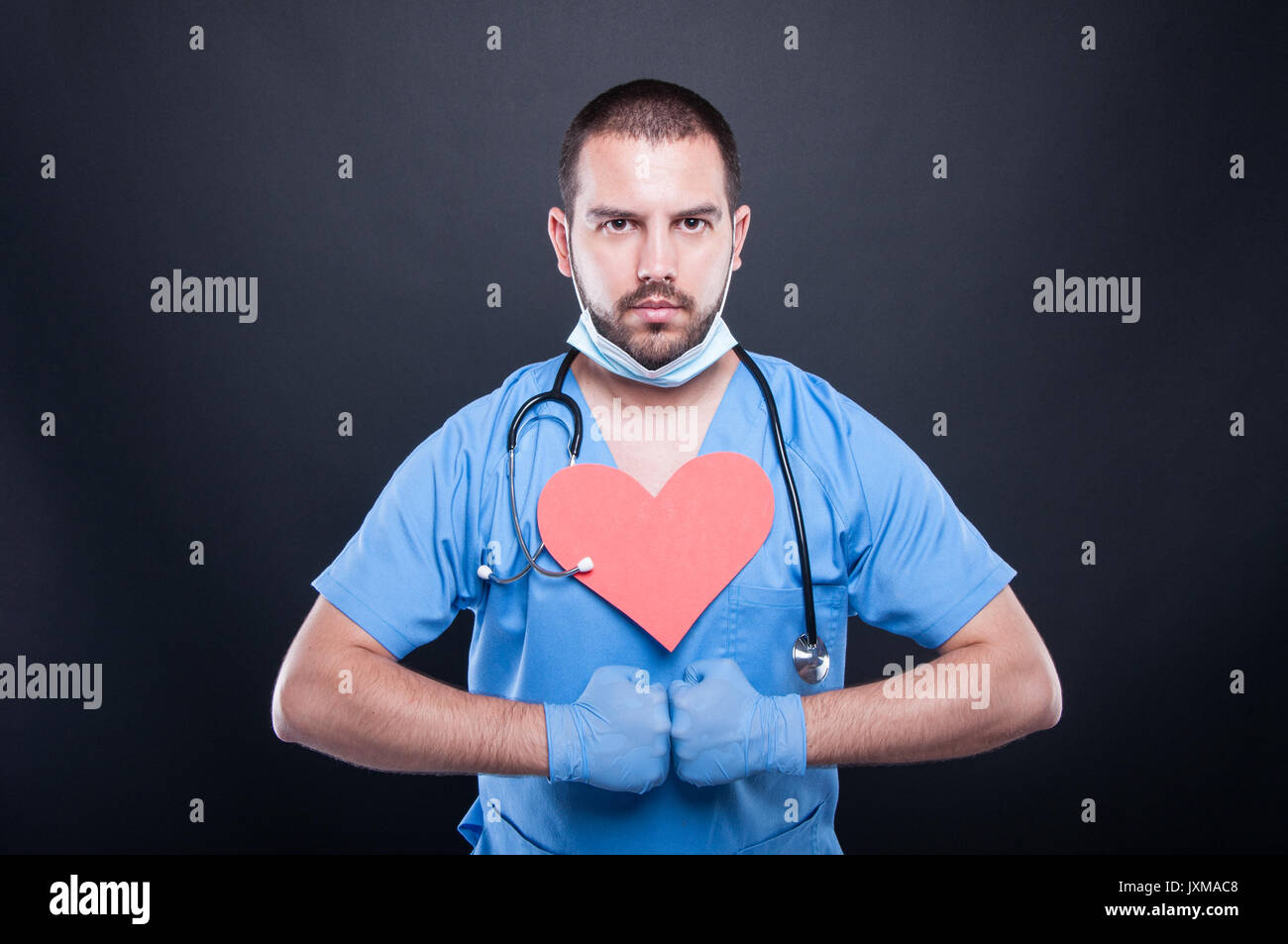 Cardiologist with red heart shape posing like being strong on black ...