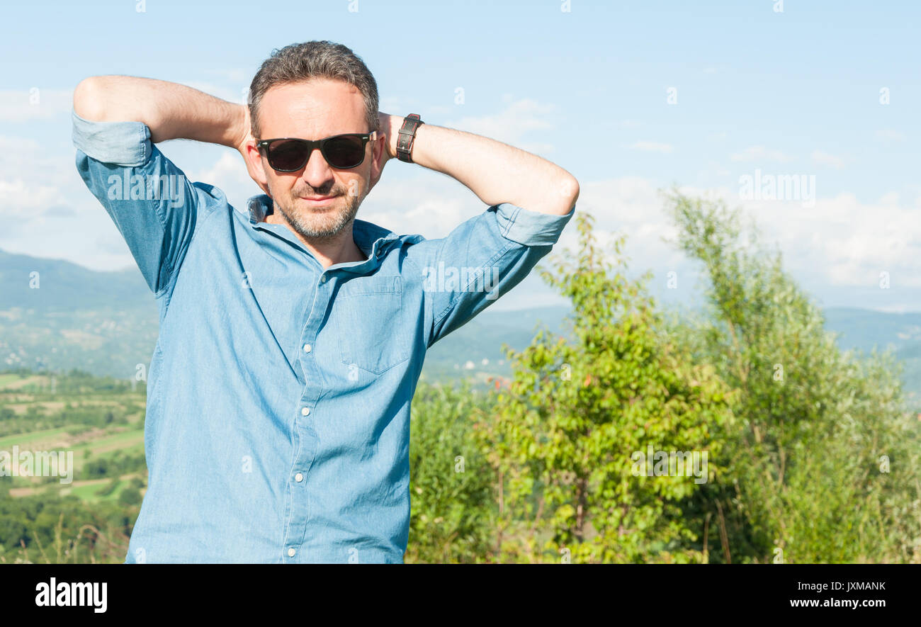 Portrait of young hipster spending time in nature and relaxing with ...