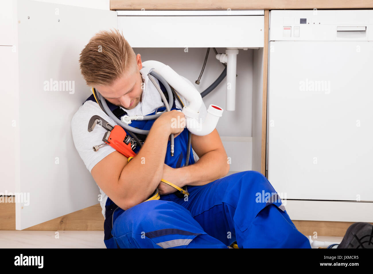 Exhausted Young Male Plumber Sleeping In Kitchen Stock Photo - Alamy