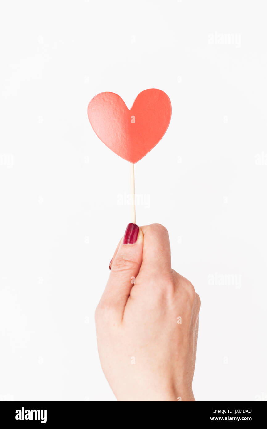 female hand holding heart photo booth prop Stock Photo - Alamy