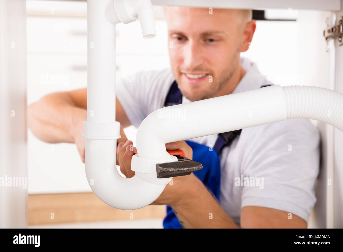 Plumber Tightening Sink Pipe With Adjustable Wrench Stock Photo - Alamy
