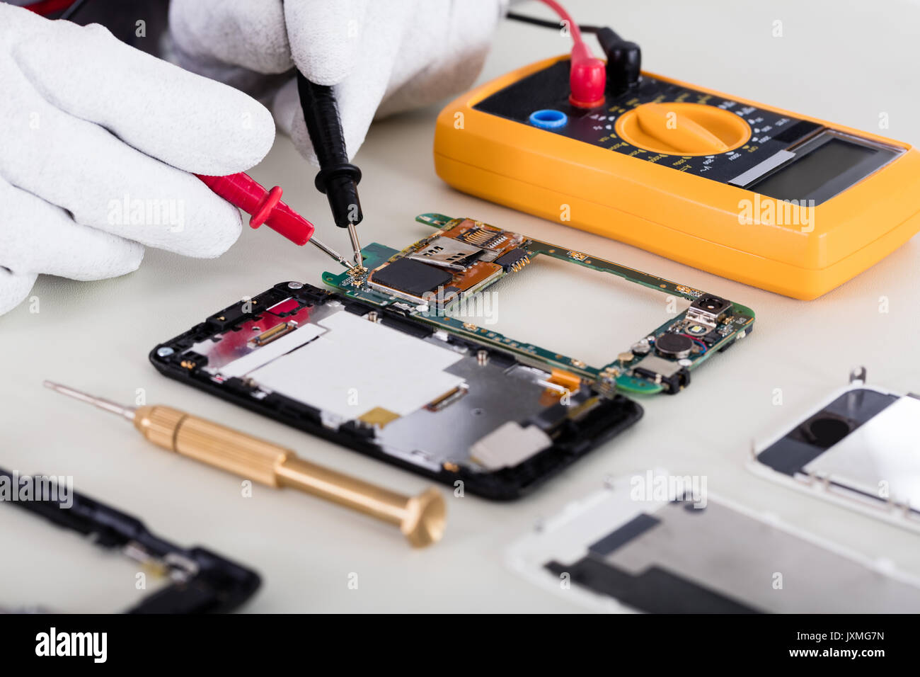 Close-up Of Person's Hand Checking Mobile Phone With Digital Multimeter ...