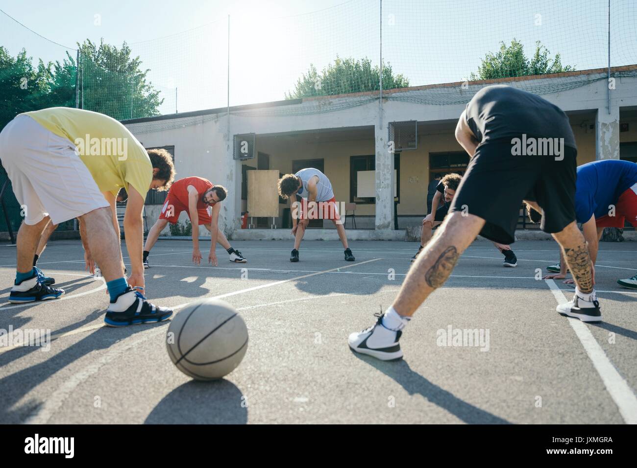 Friends on basketball court warming up Stock Photo - Alamy