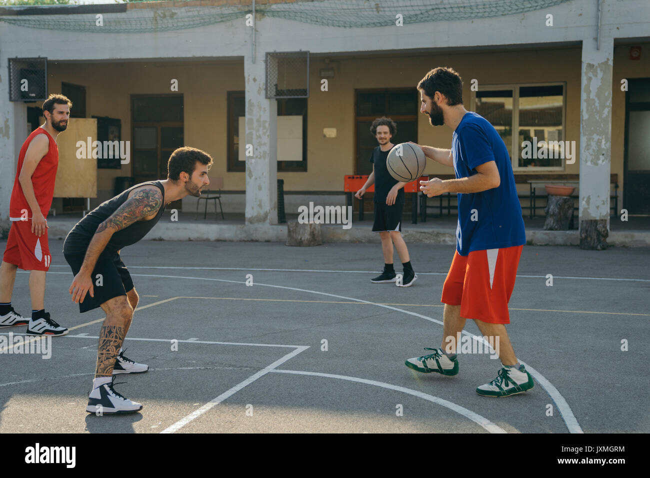 Friends on basketball court playing basketball game Stock Photo - Alamy