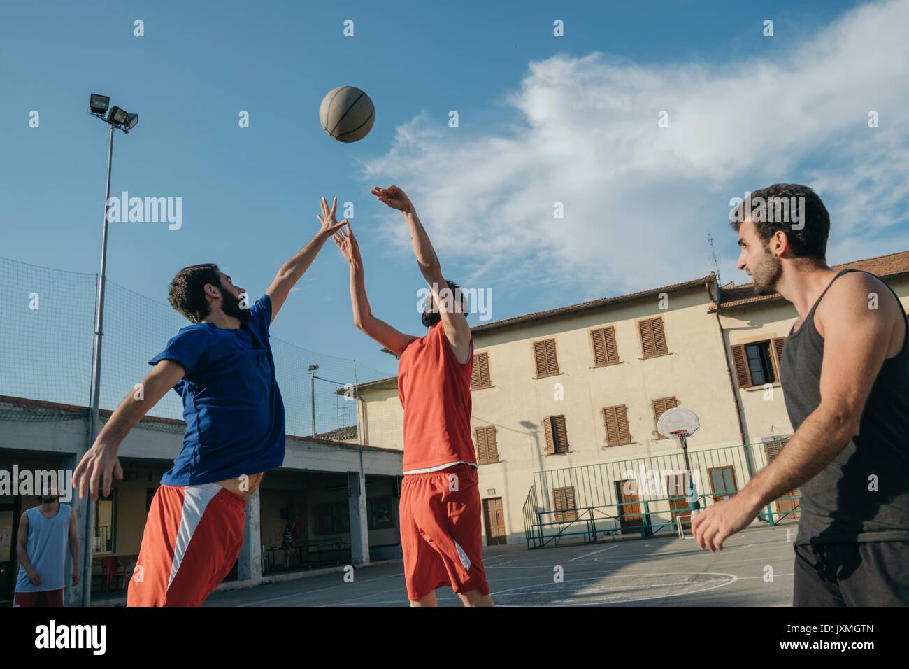 Friends on basketball court playing basketball game Stock Photo - Alamy