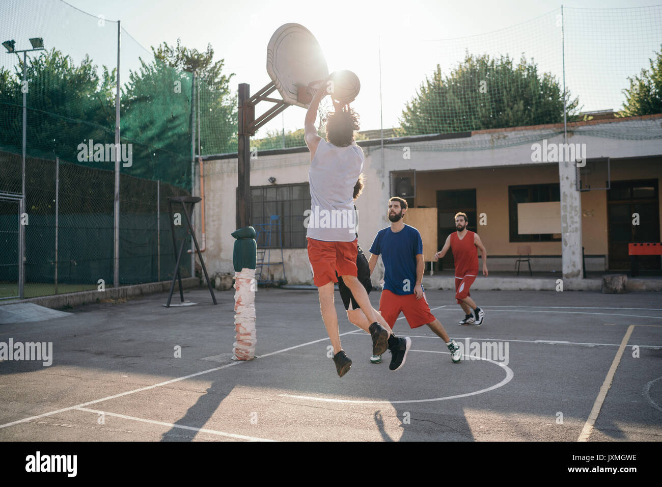 Friends on basketball court playing basketball game Stock Photo - Alamy