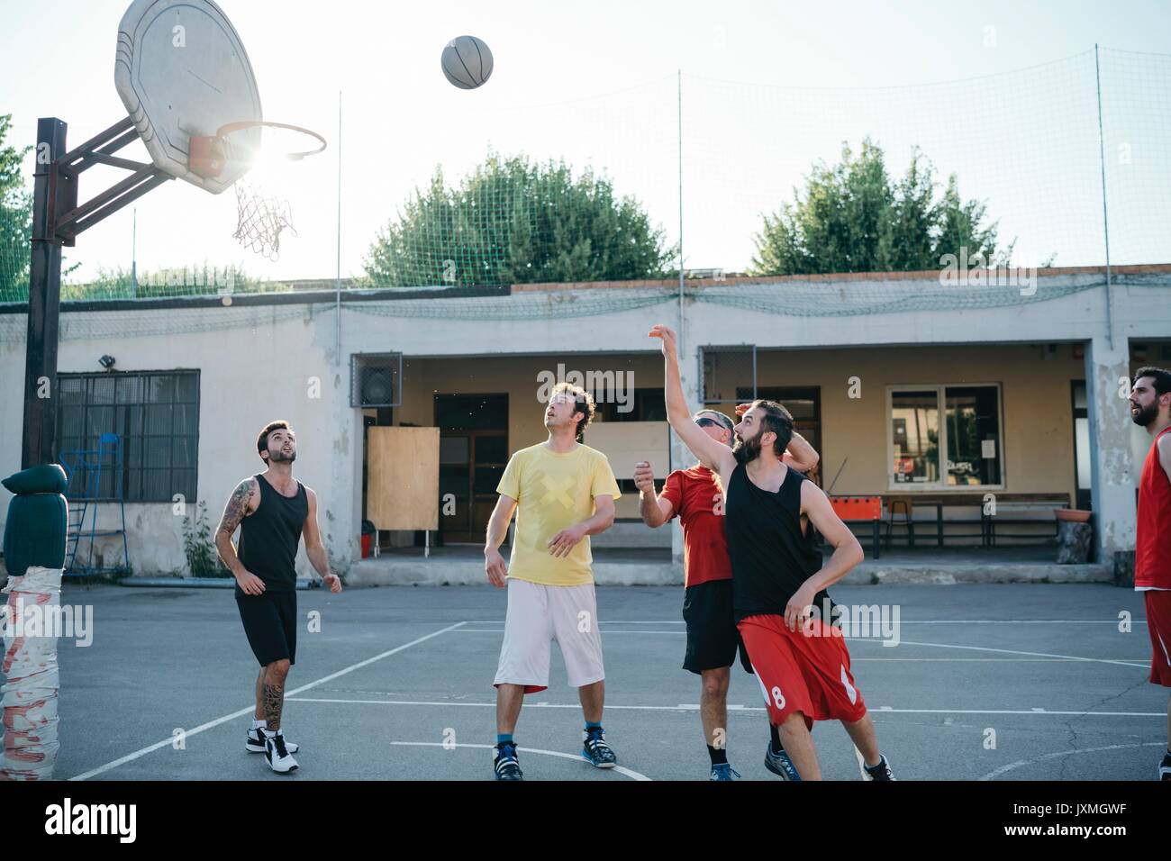 Friends on basketball court playing basketball game Stock Photo - Alamy