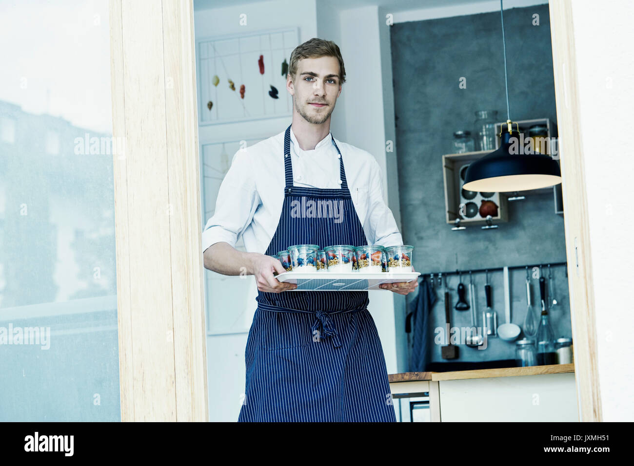 Portrait of chef holding tray of food looking at camera Stock Photo - Alamy