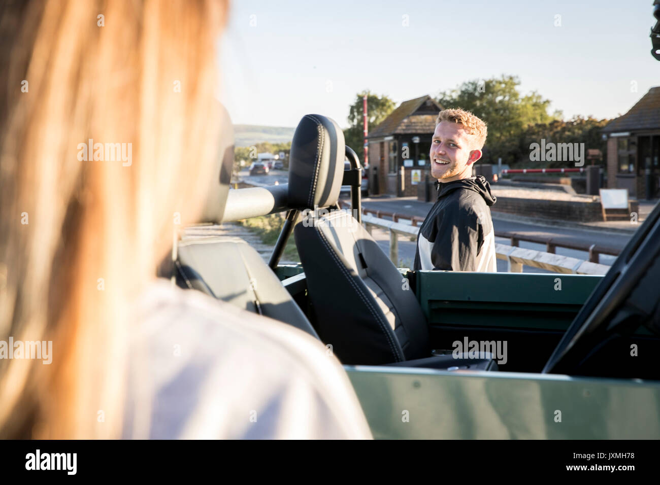 Over shoulder view of young man and girlfriend with convertible four ...