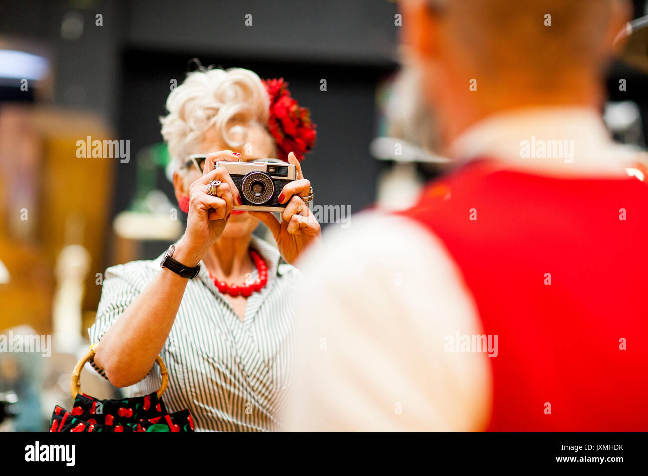 Quirky vintage woman photographing boyfriend on vintage camera in ...