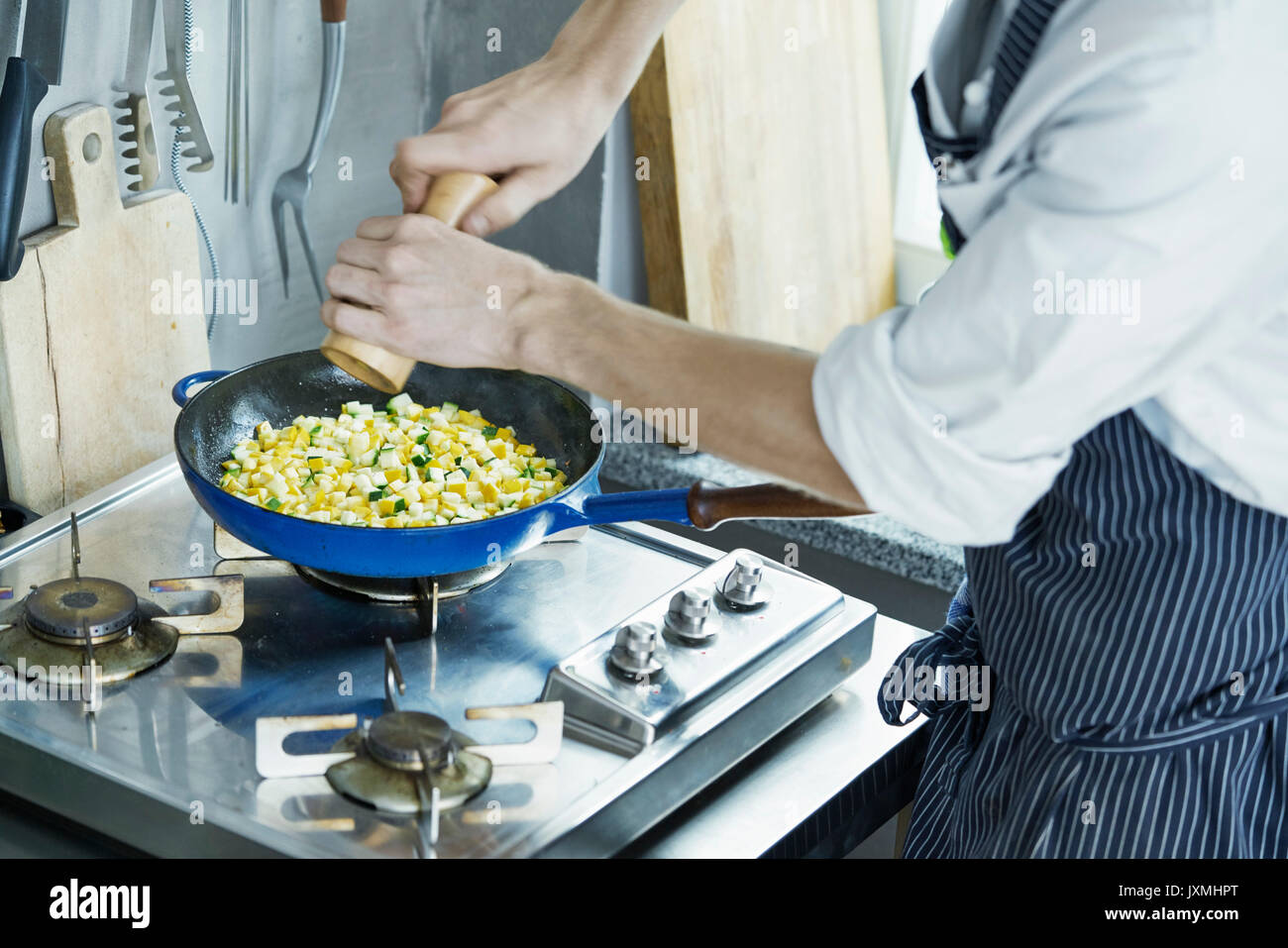 Chef seasoning vegetables in frying pan, mid section Stock Photo - Alamy