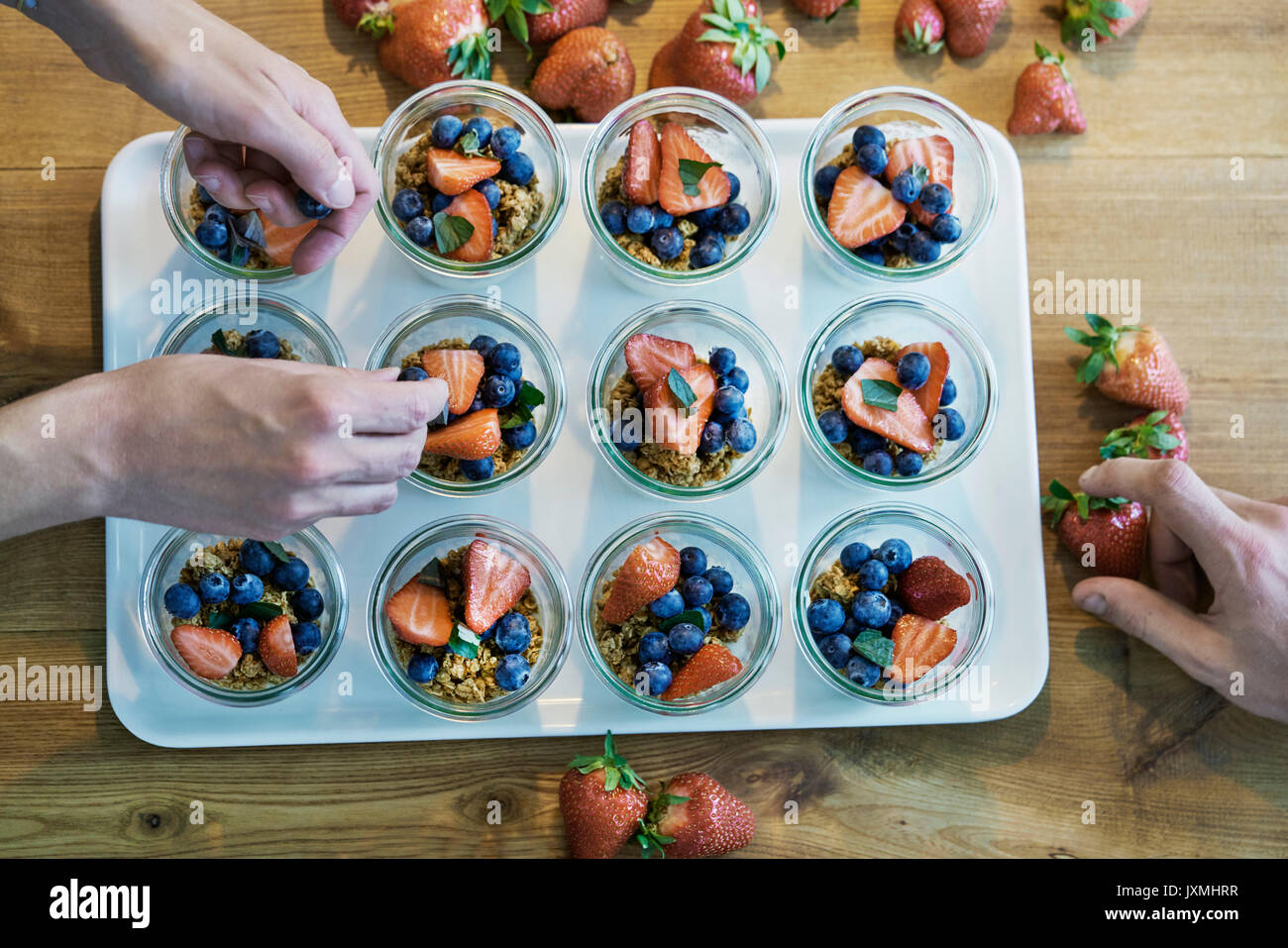Two chefs preparing berry desserts, overhead view Stock Photo - Alamy