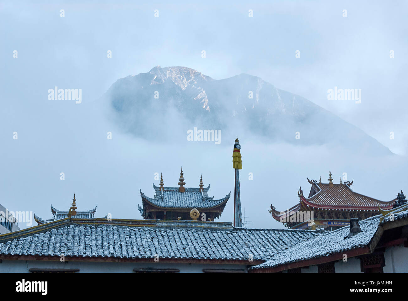 Roofs of Jingang Temple and misty mountain, Kangding, Sichuan, China ...