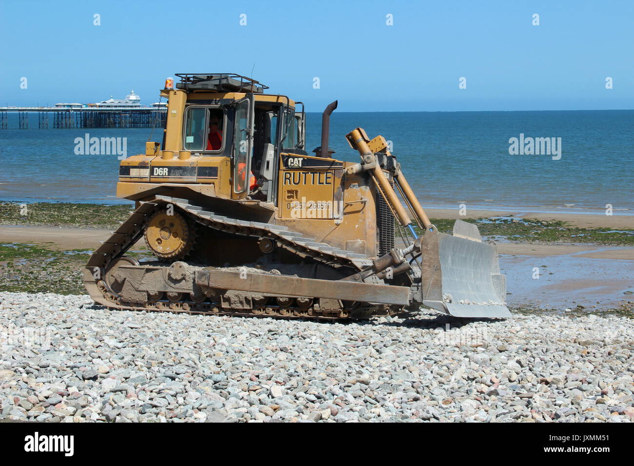 A bulldozer construction coastal defences on Llandudno beach Stock ...