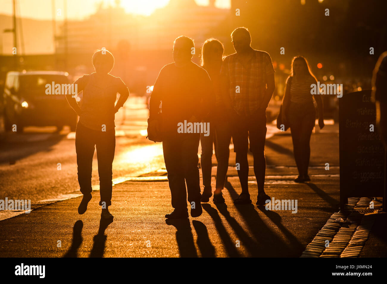 People walking down the street at sunset, in beautiful colorful color ...