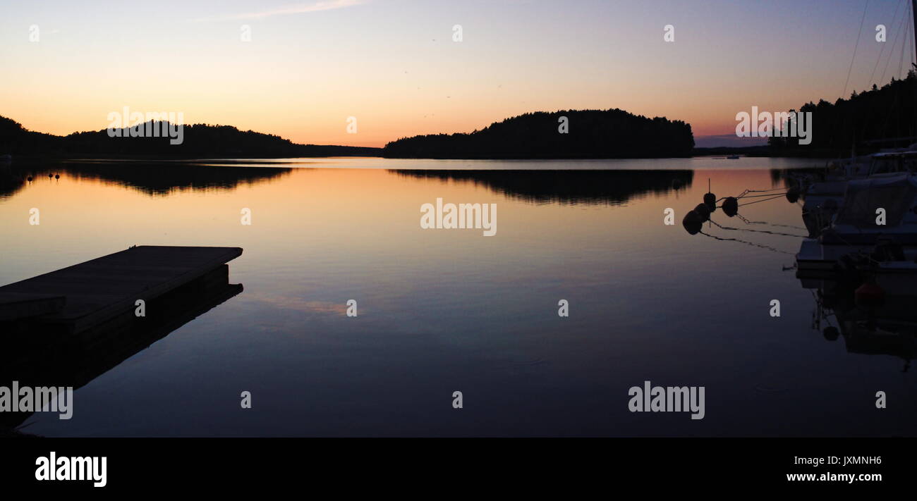 Sunset on a marina, reflection on water, jetty and some buoys Stock ...