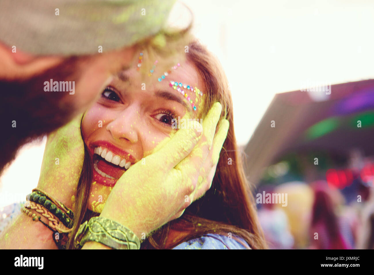 Portrait of young woman and boyfriend cupping her face with yellow ...