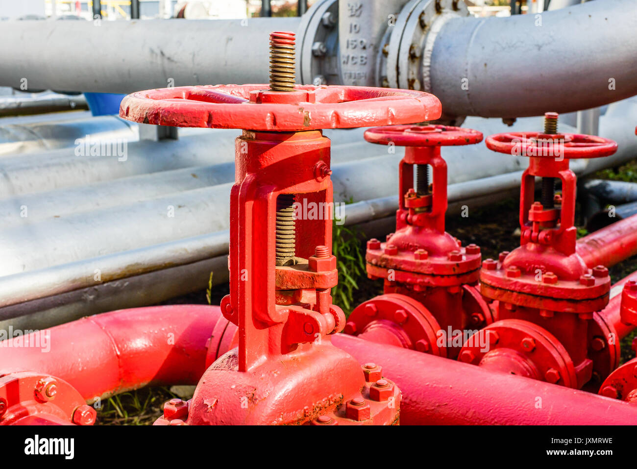 Close up of red industrial pipes and valves at biofuel industrial plant ...
