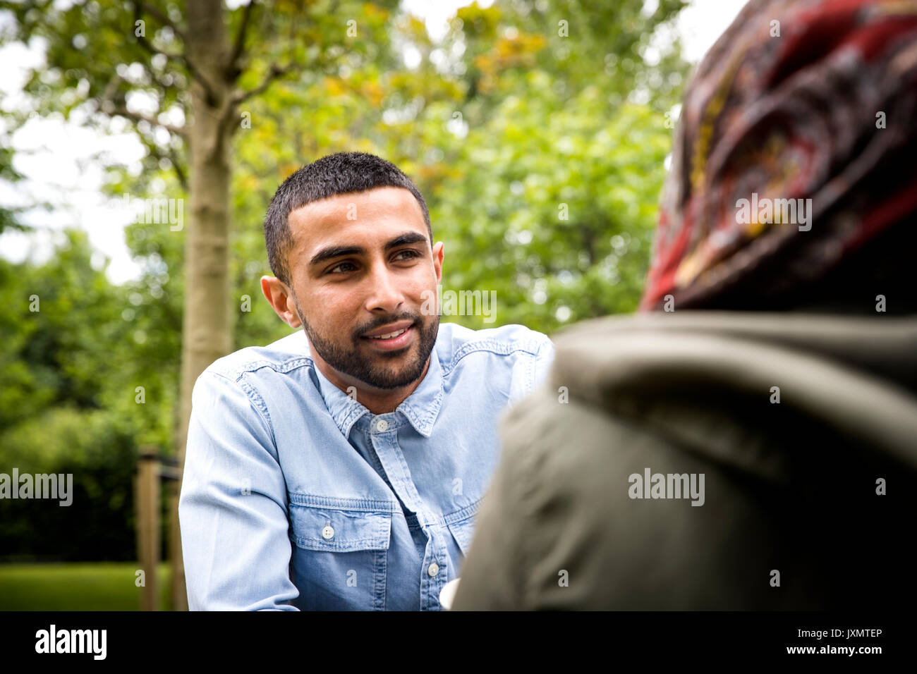 View over shoulder on man looking at friend Stock Photo - Alamy