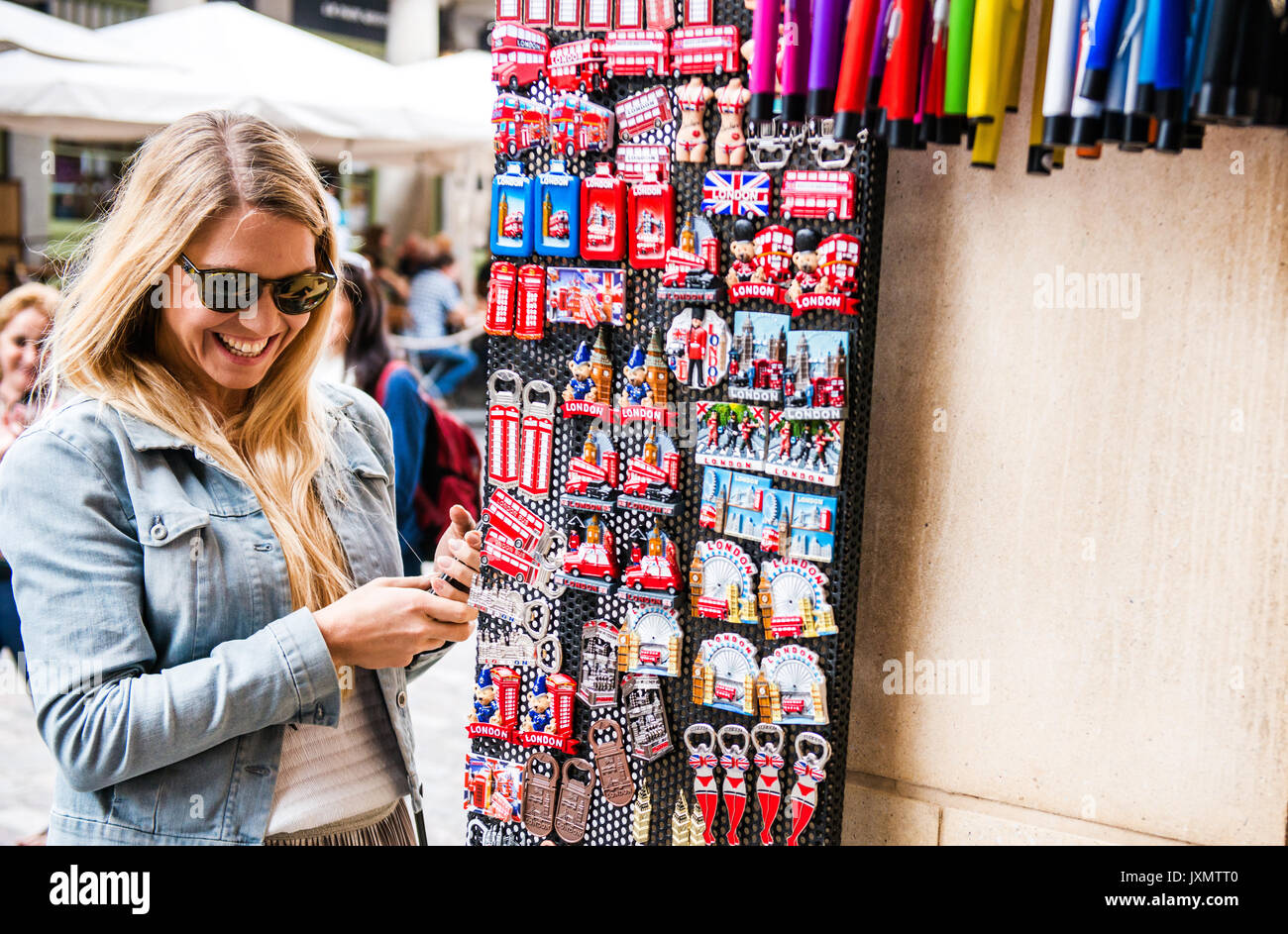 Female tourist, at souvenir stand, choosing souvenirs, smiling Stock ...