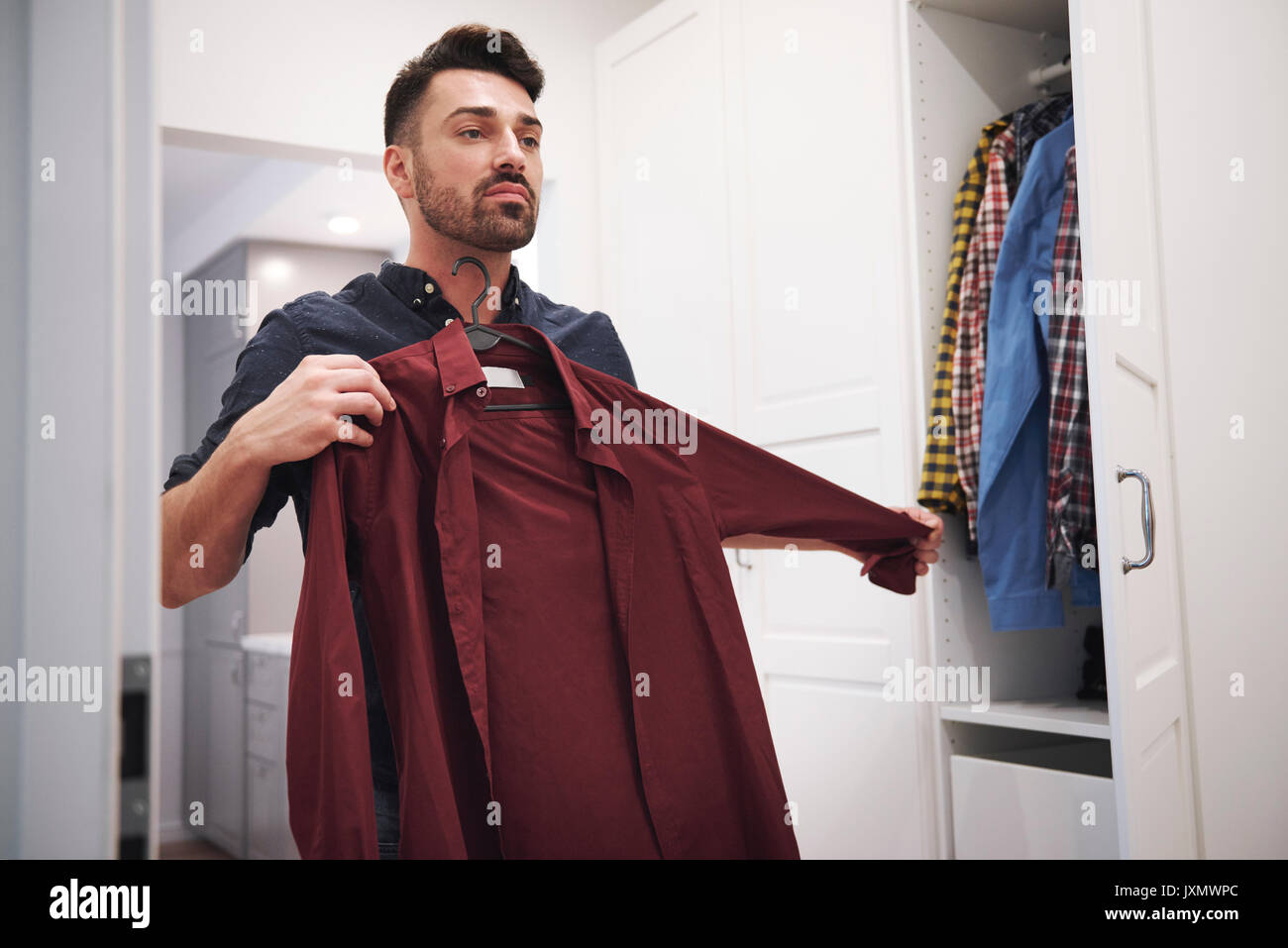 Man choosing shirt from closet Stock Photo - Alamy