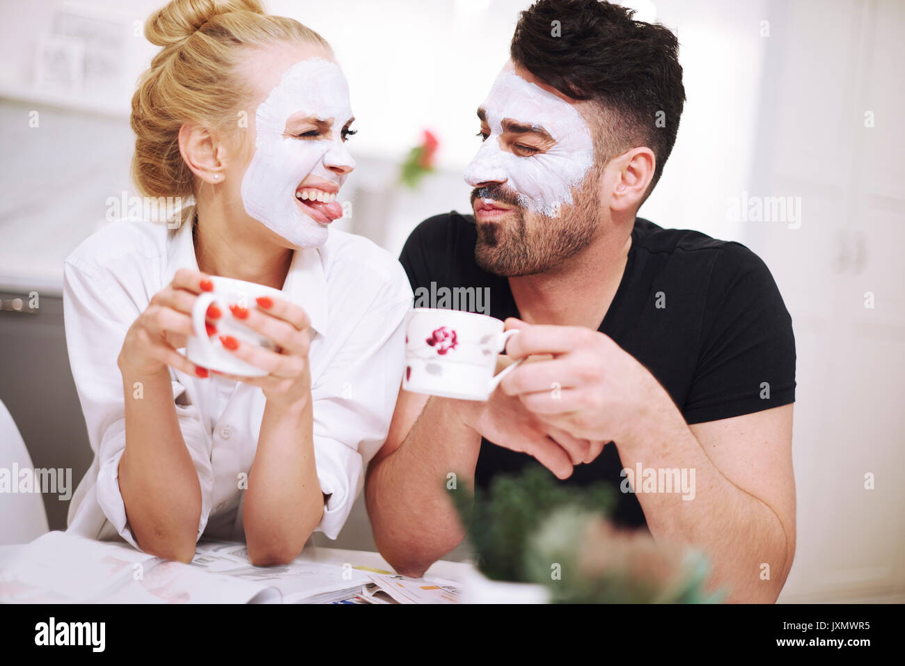 Couple with face masks face to face pulling faces Stock Photo - Alamy