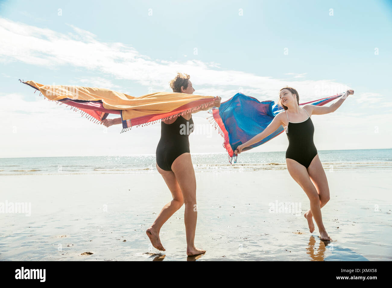 Mother And Daughter Running On Beach With Shawls In Air Folkestone Uk