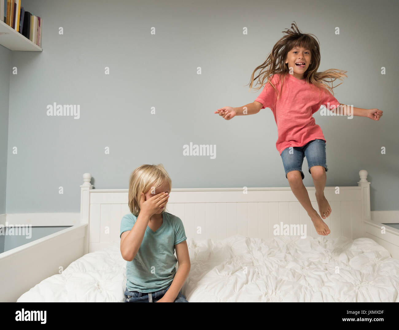 Girl in mid air jumping on bed Stock Photo - Alamy
