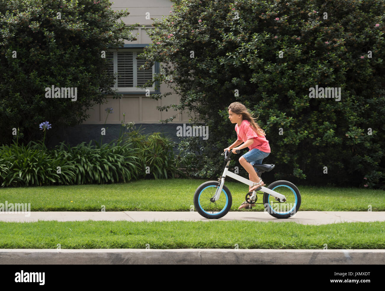 Girl in street cycling on bicycle Stock Photo - Alamy