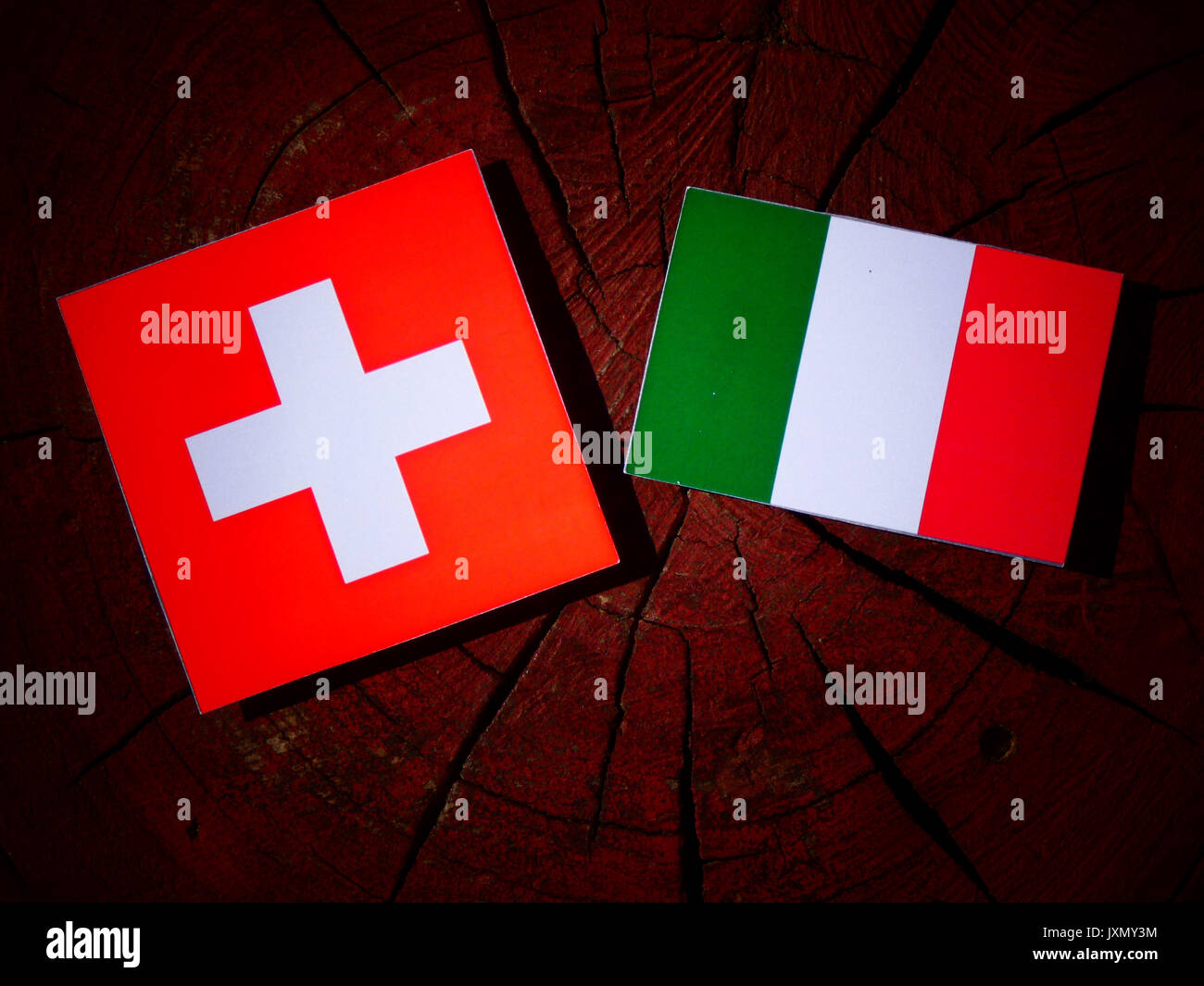 Swiss flag with Italian flag on a tree stump isolated Stock Photo - Alamy