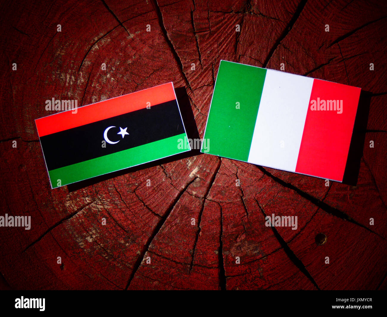 Libyan flag with Italian flag on a tree stump isolated Stock Photo - Alamy