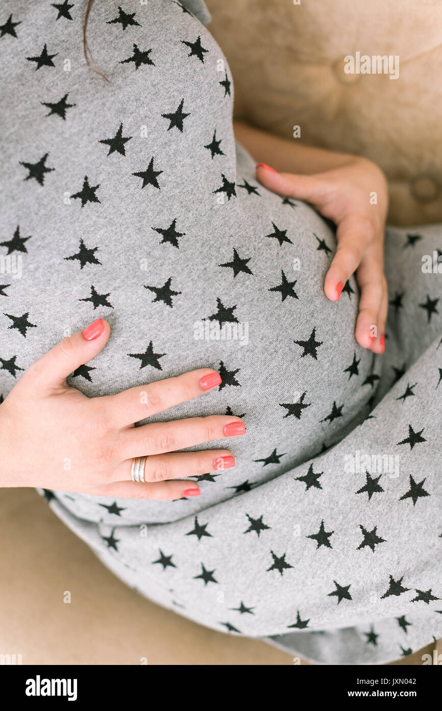 pregnancy, motherhood, birth of children concept - closeup on round ...