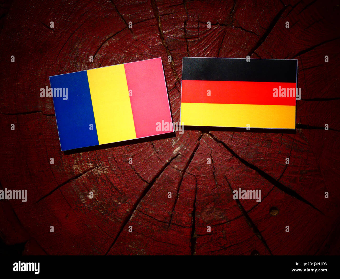 Romanian flag with German flag on a tree stump isolated Stock Photo - Alamy