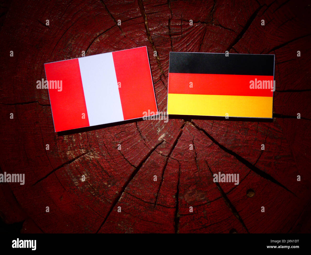 Peruvian flag with German flag on a tree stump isolated Stock Photo - Alamy