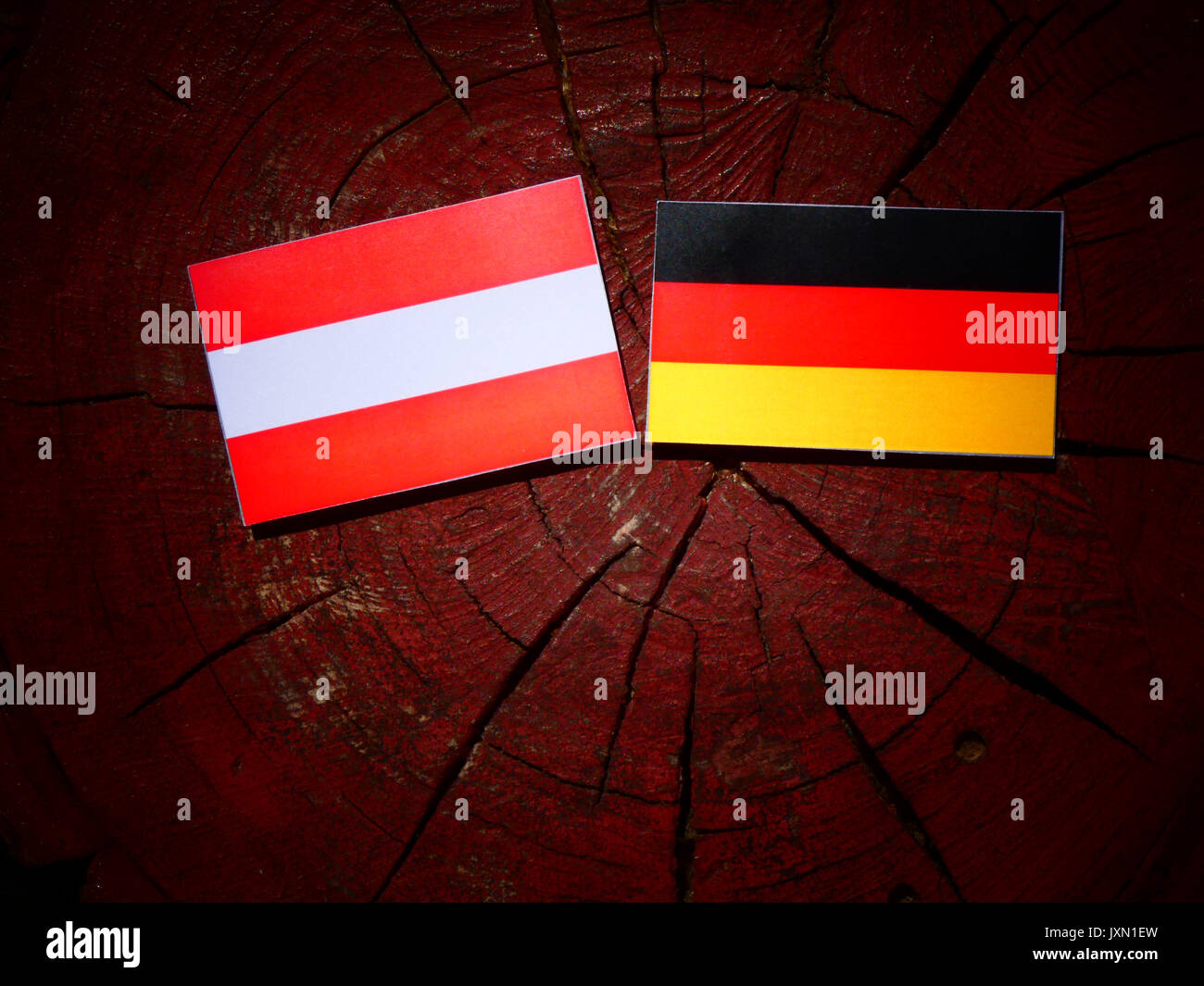 Austrian flag with German flag on a tree stump isolated Stock Photo - Alamy